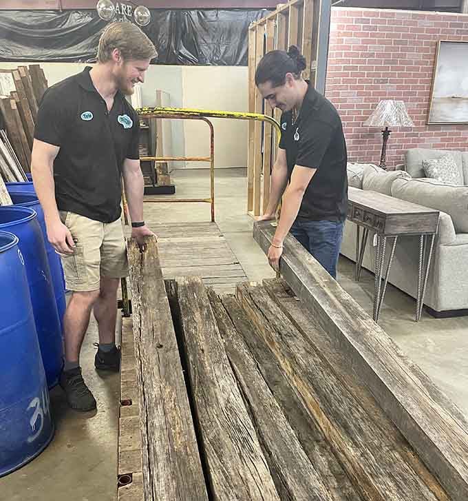 Staff members restoring reclaimed wood, because sometimes the best treasures need a little love before finding new homes.
