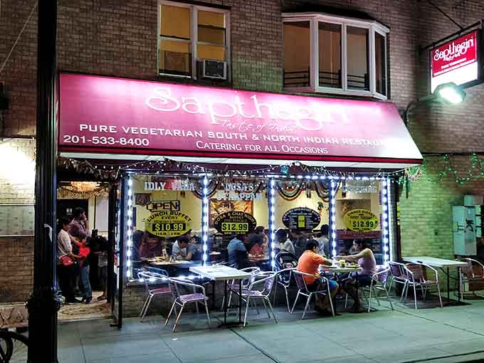 Evening lights transform the storefront into an inviting beacon, complete with outdoor seating for those perfect weather days ahead.