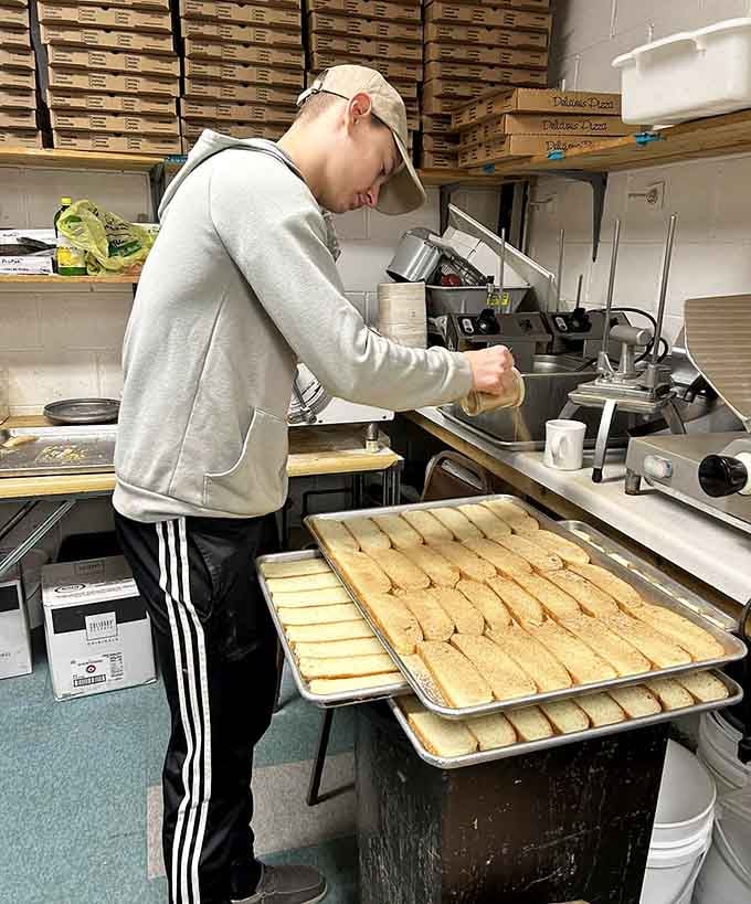 Behind the scenes, fresh pasties get crimped by hand on trays destined for hungry customers.