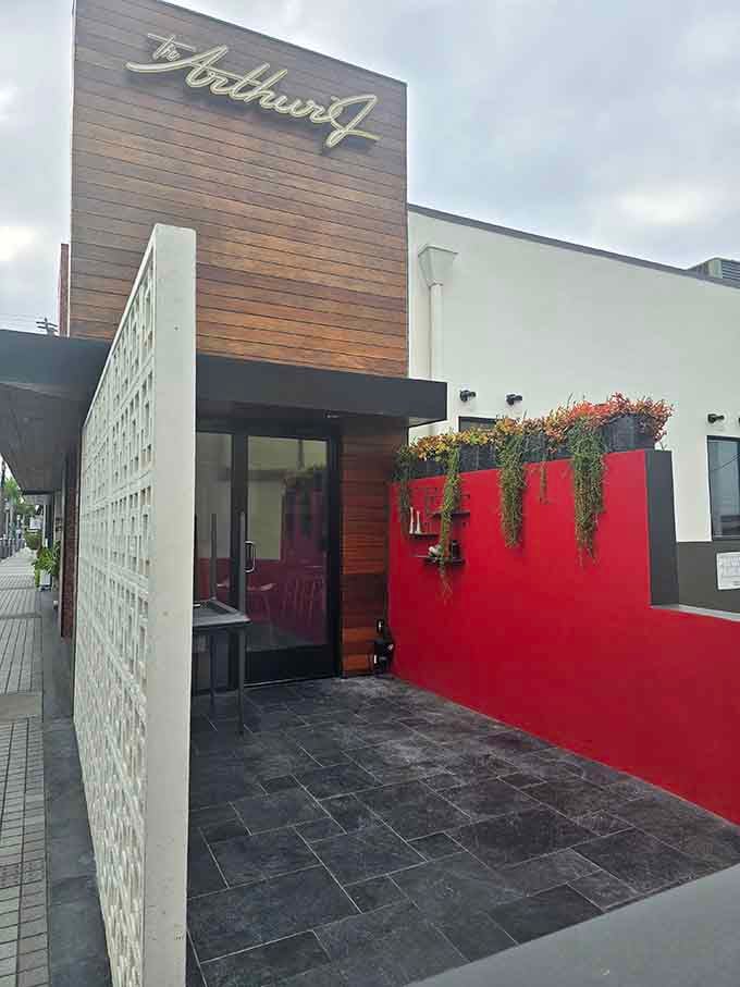 That bold red entrance with cascading greenery makes a statement: something delicious is waiting inside for you.