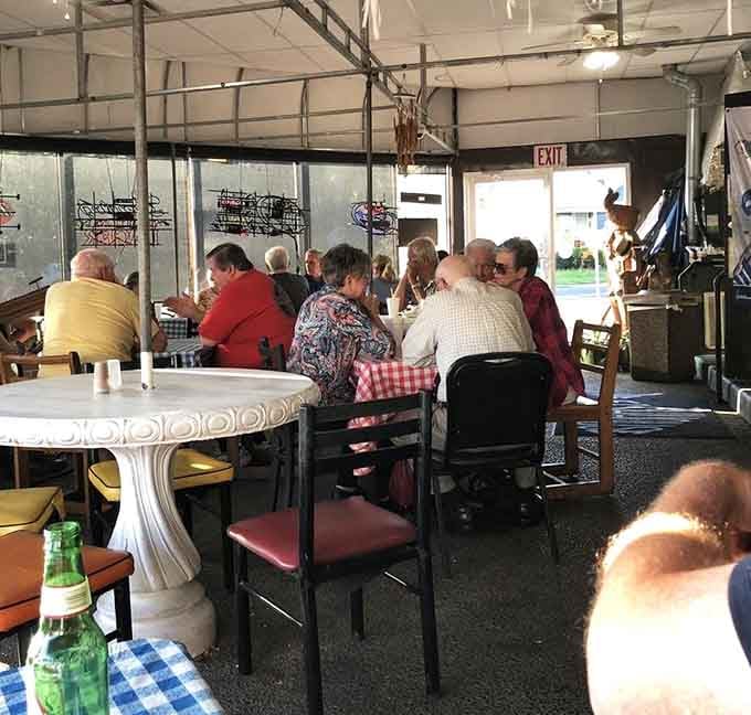 A dining room full of happy customers around a distinctive white table&mdash;this is what community dining looks like in action.