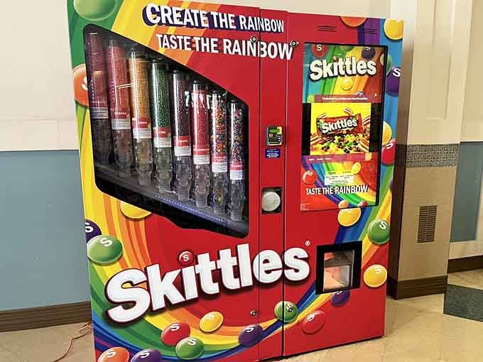 A Skittles vending machine offering rainbow therapy between stores, because sometimes shopping requires sugar reinforcement immediately.