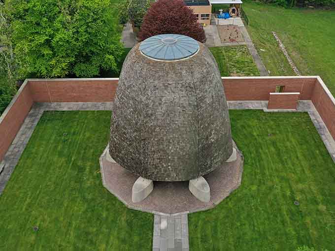 The aerial view reveals the genius: a perfect circle open to infinity, grounded by brick walls.
