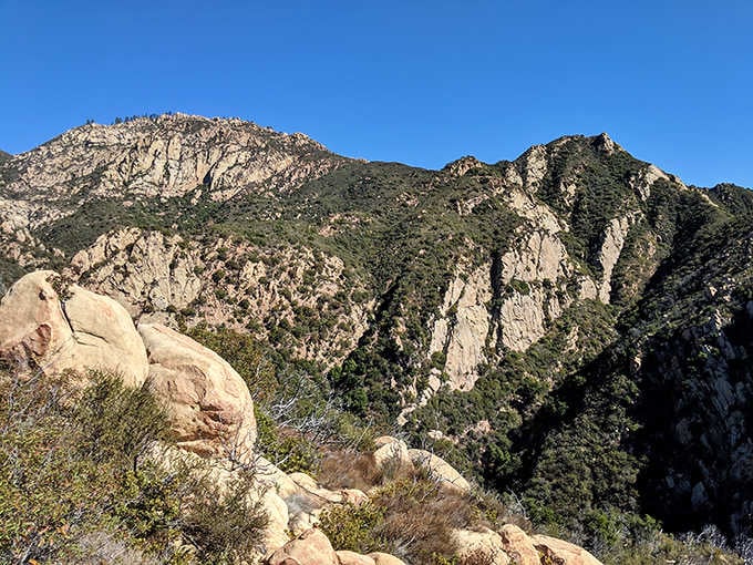 Cathedral Peak looms in the distance, standing guard over the canyon like nature's own security system for these hidden treasures.