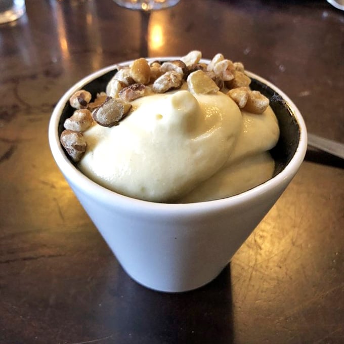 Creamy butterscotch dessert topped with nuts delivers that perfect sweet ending that makes you consider ordering a second round immediately.