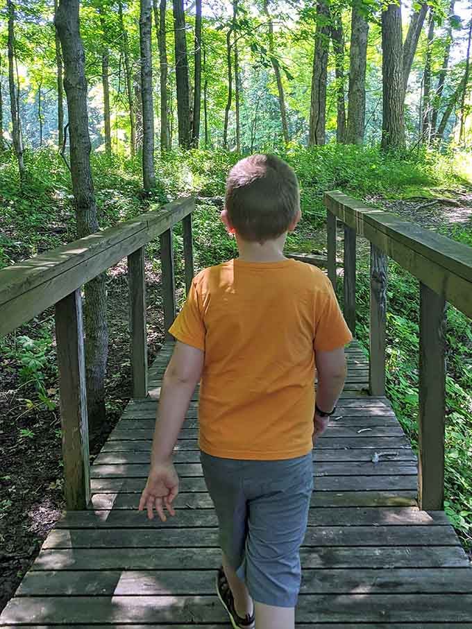 Young explorers crossing wooden bridges, living out adventures that don't require batteries or WiFi to enjoy.