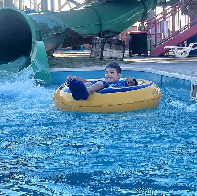 Pure joy captured mid-float, proving that yellow inner tubes are basically happiness donuts for the water.