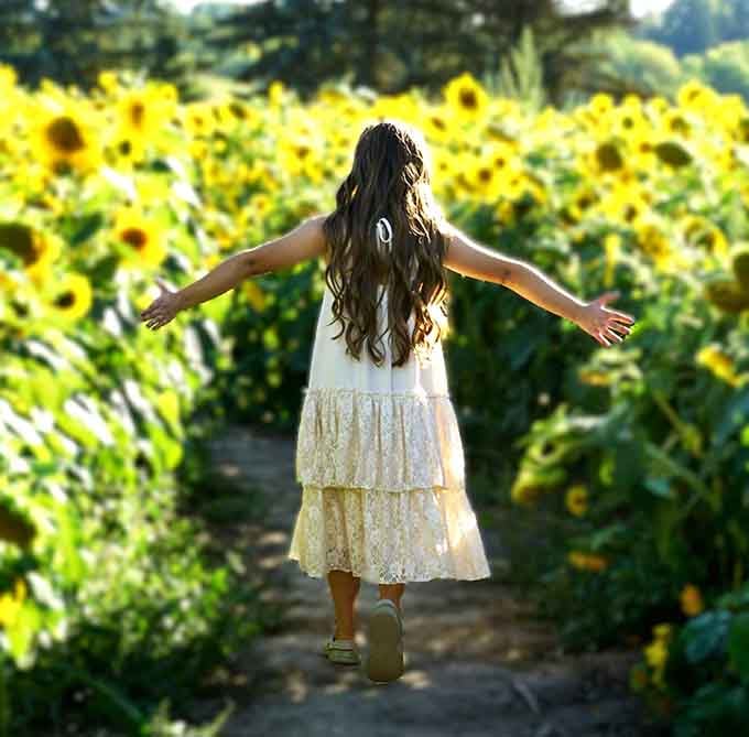 Arms spread wide in pure delight, this visitor perfectly captures the feeling everyone experiences walking these rows.