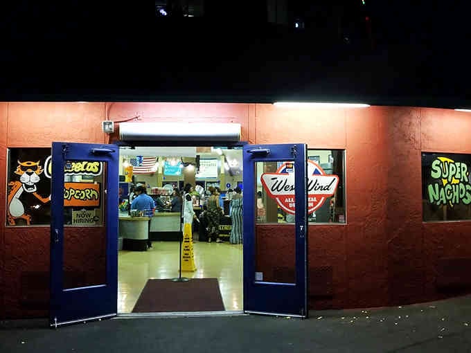 The snack bar lobby welcomes you with that familiar movie theater smell we all secretly love.