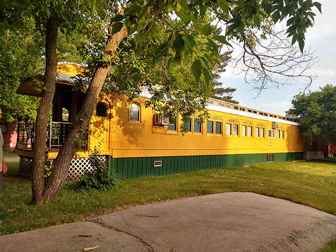 The full-length yellow beauty proves these aren't miniature replicas but genuine railroad cars turned cozy retreats.