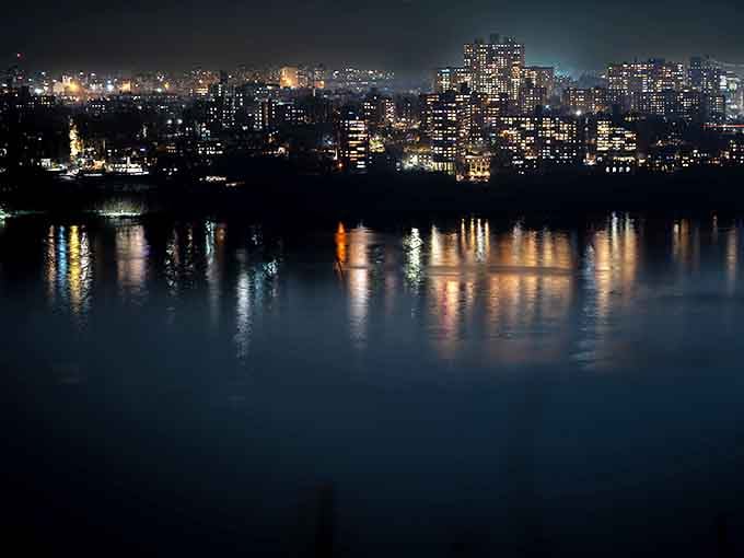 City lights twinkling across the water at night prove that some views are worth staying past your bedtime.