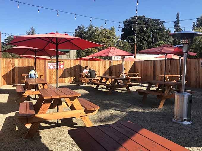 Outdoor seating under red umbrellas where California sunshine meets serious barbecue, a winning combination always.