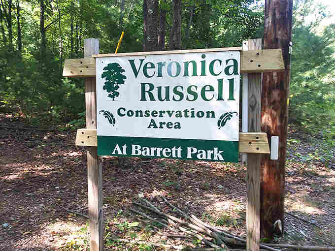 The Veronica Russell Conservation Area sign marks your entry into protected wilderness, where nature still calls the shots.