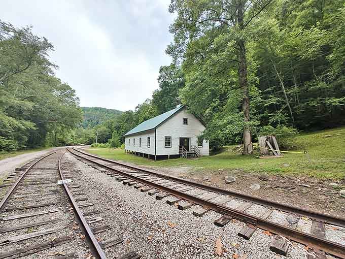 Railway tracks stretching toward a white building at Blue Heron tell stories of coal, community, and Kentucky mountain heritage.