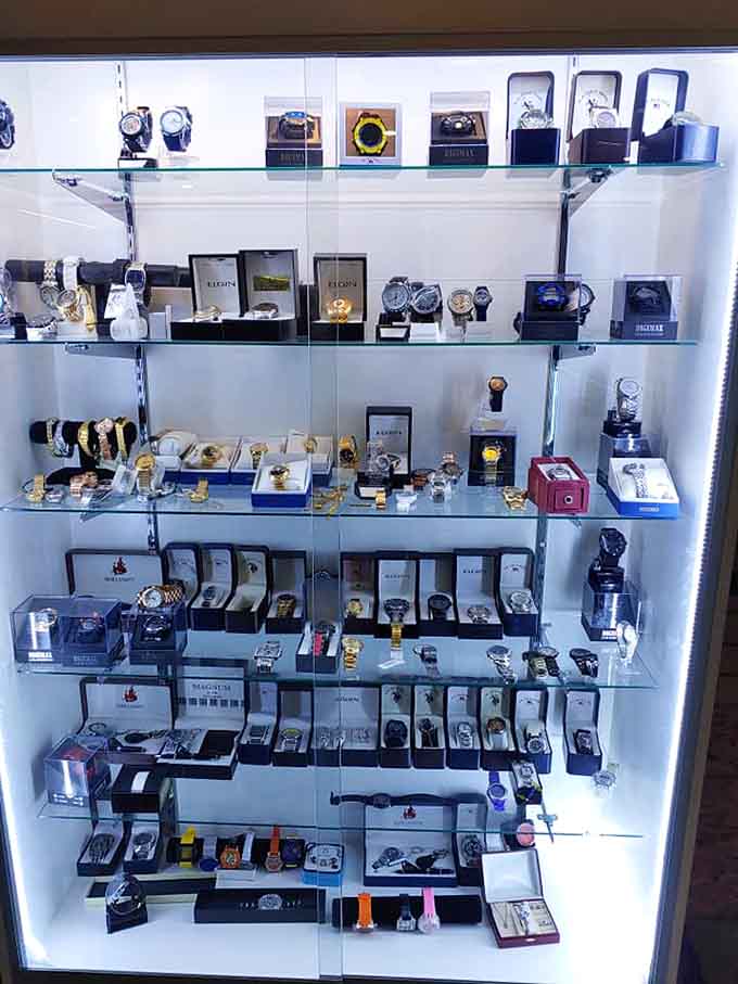 Watches gleaming behind glass like tiny time machines, each one fancier than your wrist probably deserves.