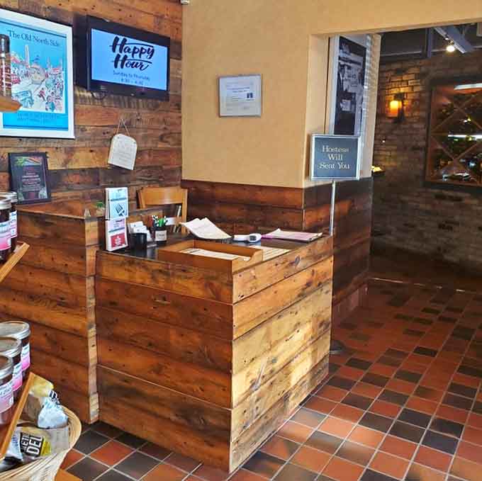 The rustic wood reception area with its "Hostess Will Seat You" sign sets a welcoming tone before you've even ordered.