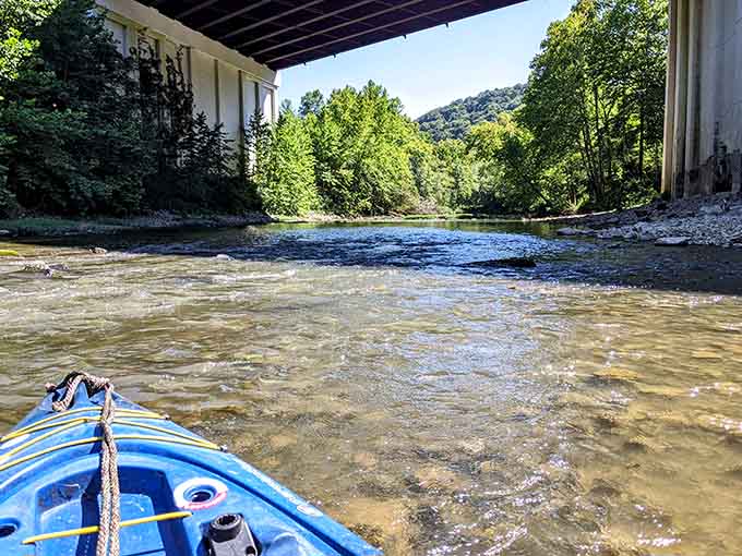 Paddling beneath that bridge, you're gliding through water so clear you can see straight to the rocky bottom below.