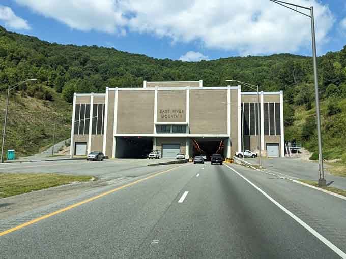 Blue skies and rolling mountains showcase the natural beauty that this tunnel helps travelers navigate with remarkable efficiency.