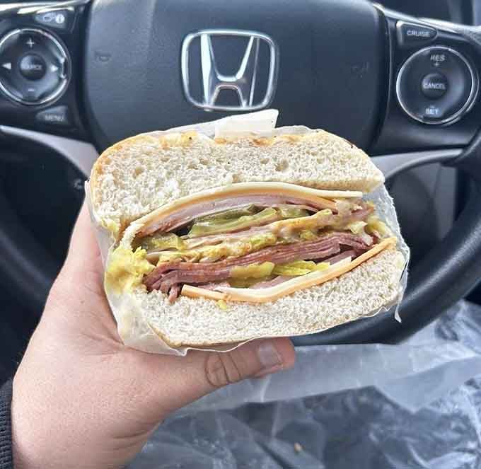 Cross-section perfection: multiple meats, cheese, and toppings arranged like edible art that tastes even better than it looks.