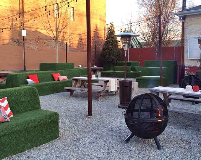 The outdoor patio with artificial turf seating proves that quirky design choices can create surprisingly comfortable gathering spots.