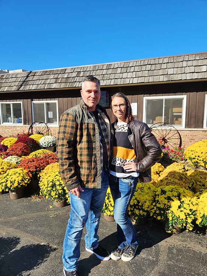 Happy visitors surrounded by fall flowers, proof that Garwood Orchards creates instant smiles and lasting memories.