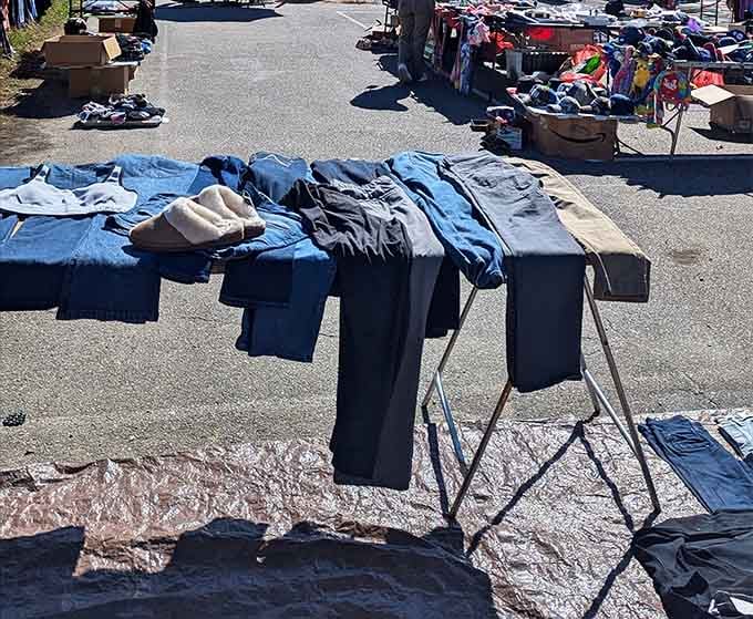 Pants draped over racks like fabric flags, offering affordable wardrobe solutions for those who appreciate pre-loved denim options.