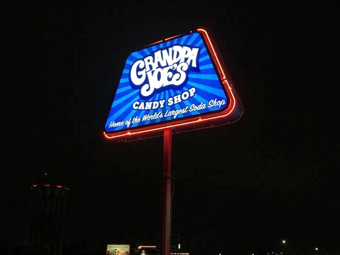 The glowing sign at night guides sugar pilgrims home like a beacon of sweetness in the darkness.