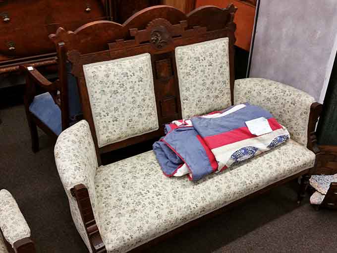 This ornate settee with delicate upholstery whispers of parlor conversations and Sunday visits when furniture meant something beyond just functional seating.