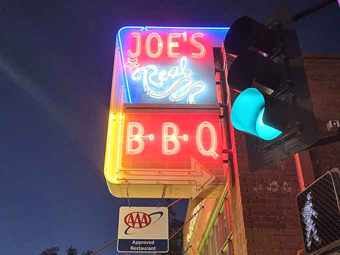 That glowing neon sign beckons like a barbecue lighthouse, guiding hungry souls to smoky salvation below.