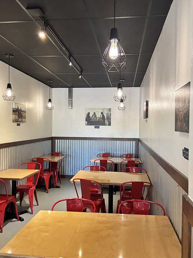 Red metal chairs and industrial lighting create a casual dining space where the focus stays on your plate.