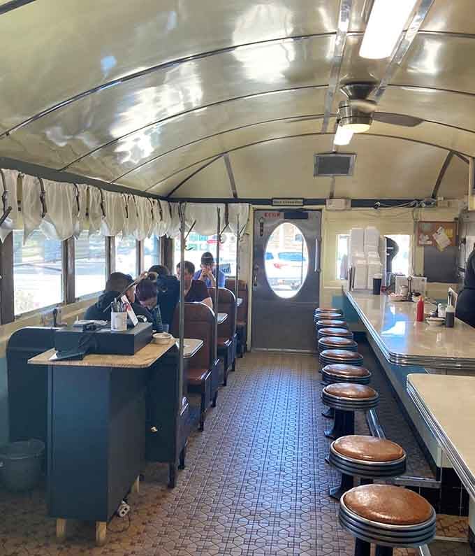 That classic railroad car interior with booths and counter creates the timeless atmosphere where strangers become regulars over scrambled eggs.