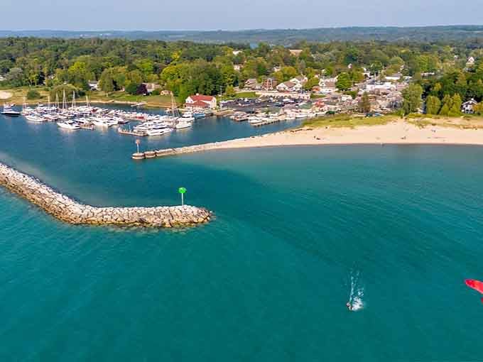 Aerial views reveal Leland's perfect harbor, where turquoise waters meet sandy beaches in pure Michigan magic.