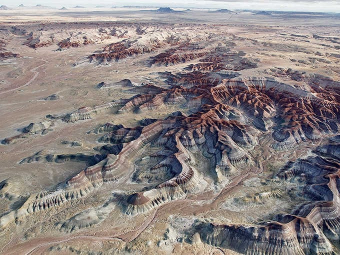 The aerial perspective reveals patterns and textures invisible from ground level, like reading Earth's autobiography from a bird's vantage.