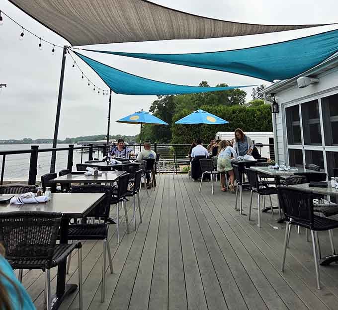 Shaded patio seating overlooking the marina: where boat watching becomes an official sport worth mastering completely.