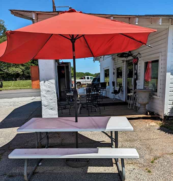 Picnic tables under bright umbrellas offer the perfect spot for savoring burgers in fresh country air.