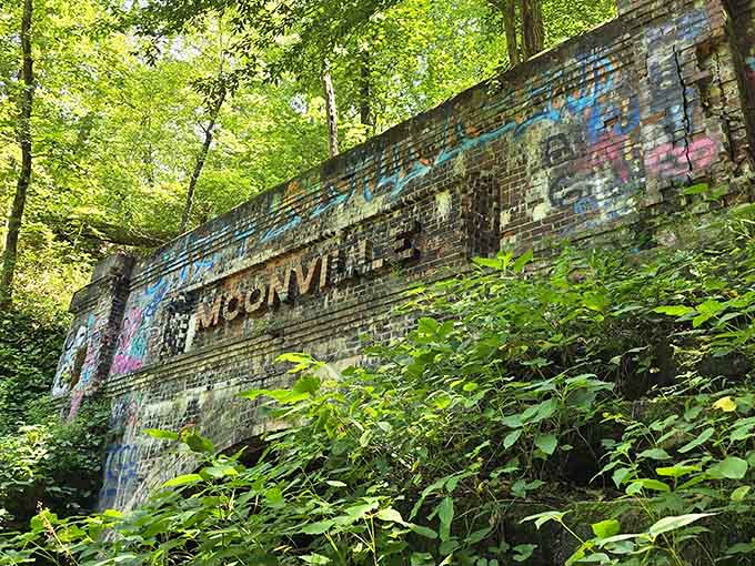 The "Moonville" inscription carved into the hillside above serves as the town's lasting epitaph, refusing to be forgotten by the forest.