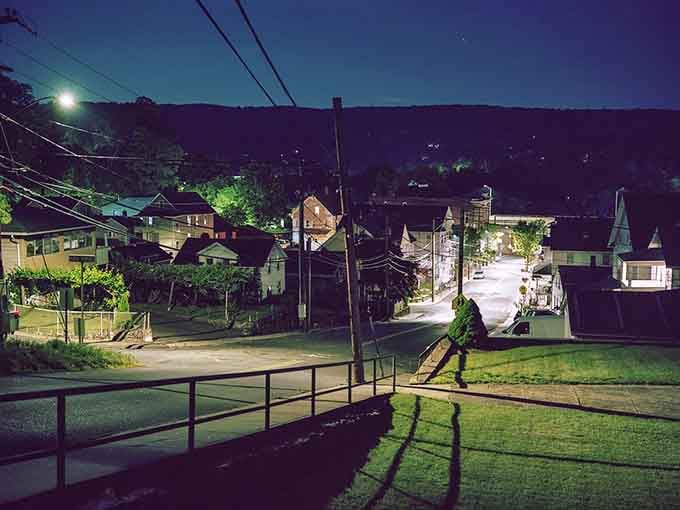 Evening lights glow across the hillside neighborhood, painting a Norman Rockwell scene that's actually affordable to live in.