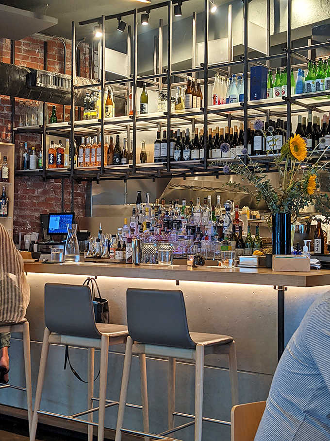 The sleek bar backed by industrial shelving stocked with sake and spirits invites you to settle in properly.
