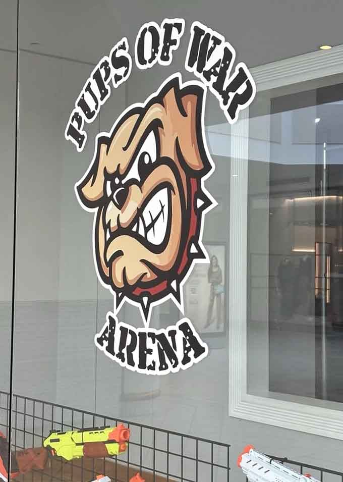 The bulldog mascot grins with appropriate ferocity, perfectly capturing the playful aggression that defines this wonderfully ridiculous foam dart experience.