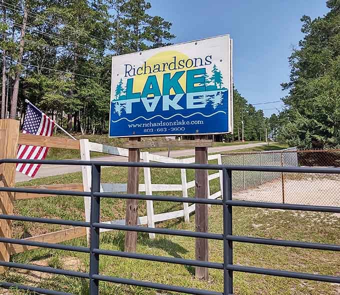 The welcoming sign that promises adventure, complete with website and phone number for planning your lakeside escape.