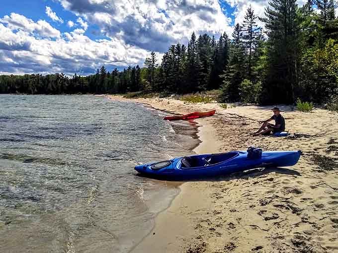 Two kayaks rest on sandy shores where paddlers can explore waters so clear you'll swear you're somewhere far more exotic.