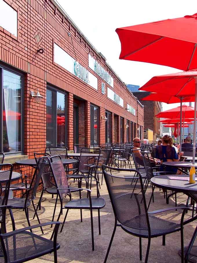 Red umbrellas create a cheerful outdoor oasis where you can enjoy your lobster roll with a side of people-watching.