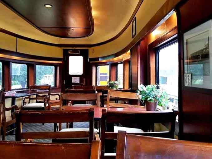 The elegant dining car interior features rich wood tones and comfortable seating where your meal comes with ever-changing scenery.