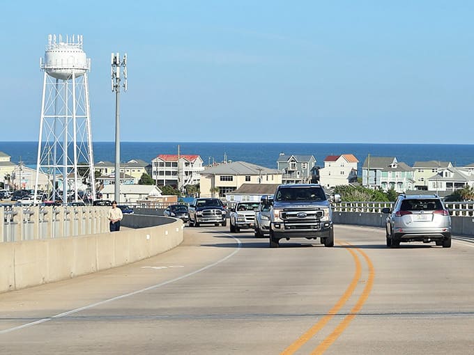 The road leading to the beach, where that water tower serves as your beacon of coastal happiness ahead.