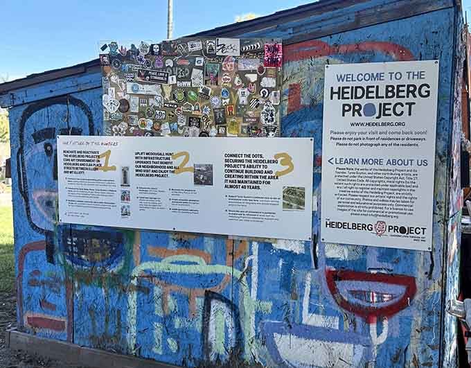 The welcome sign explains the mission while layers of found objects behind it demonstrate the philosophy in action.