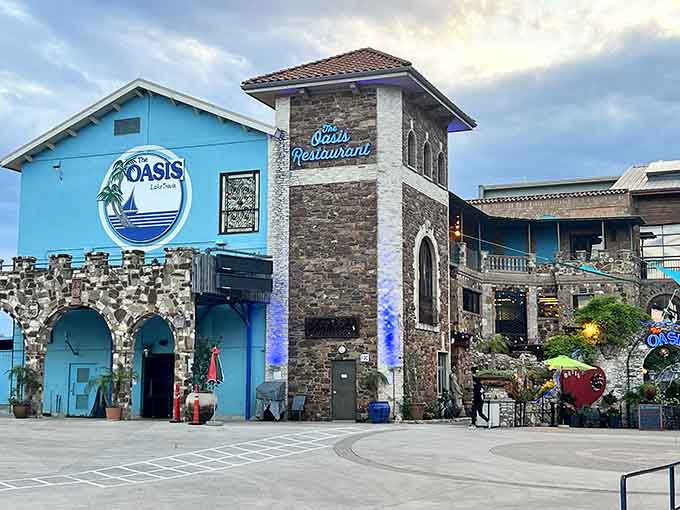 Stone archways, blue walls, and the Oasis sign lit up at dusk, a landmark that earns every bit of its reputation.