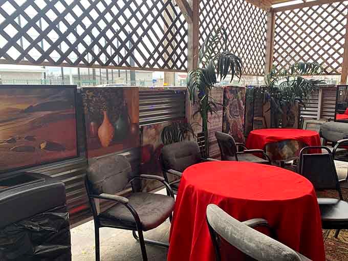 Red tablecloths and artistic touches transform simple outdoor seating into a warm, welcoming gathering space for all.