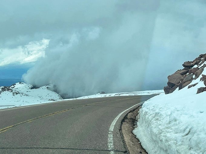 Towering snow walls flank the roadway in early season, creating winter's grand finale before summer finally gets its turn onstage.