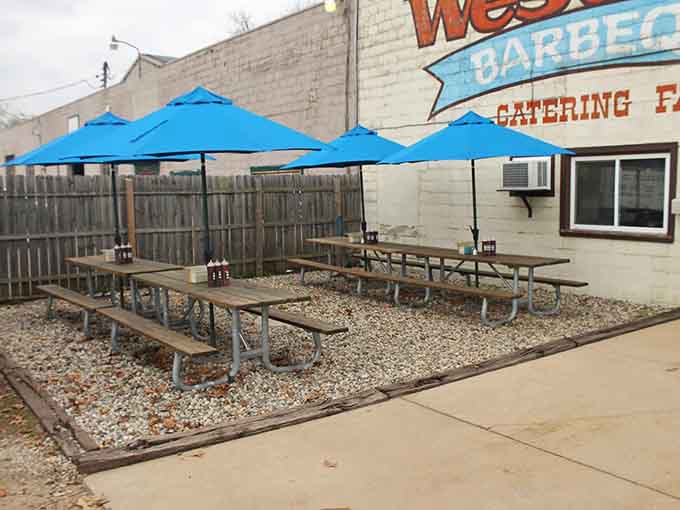 Blue umbrellas providing shade while you tackle a plate of Texas-style barbecue in pure Michigan sunshine.