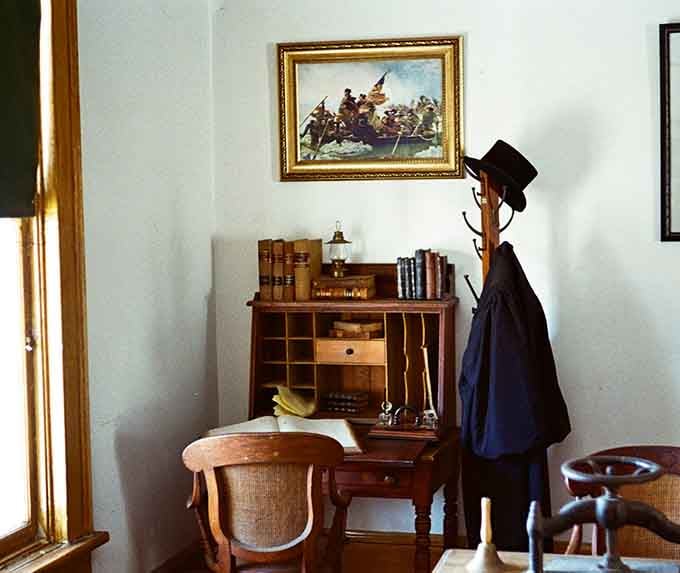 A gentleman's desk awaits its owner, hat hanging ready as if he just stepped out and might return any moment.